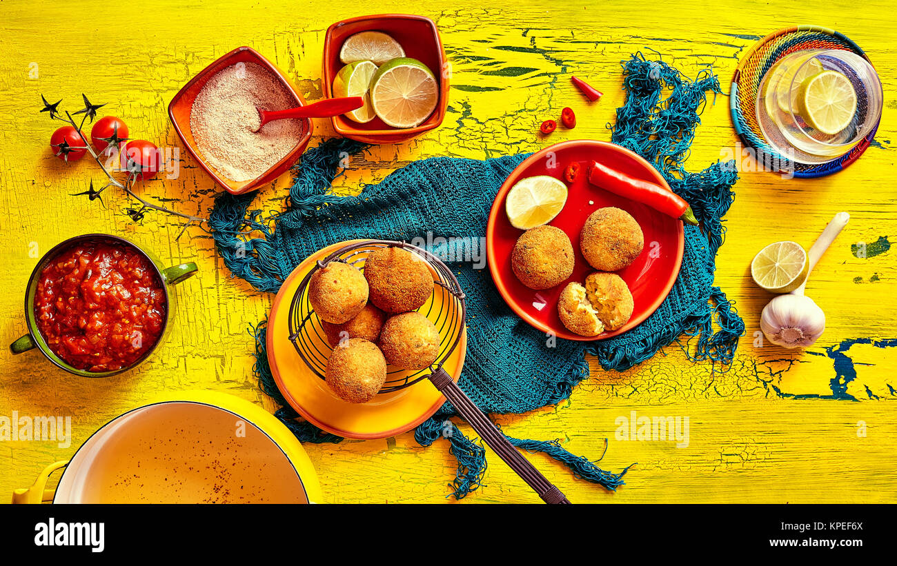 Brazilian speciality of bolhinos in frying basket and plates surrounded ...