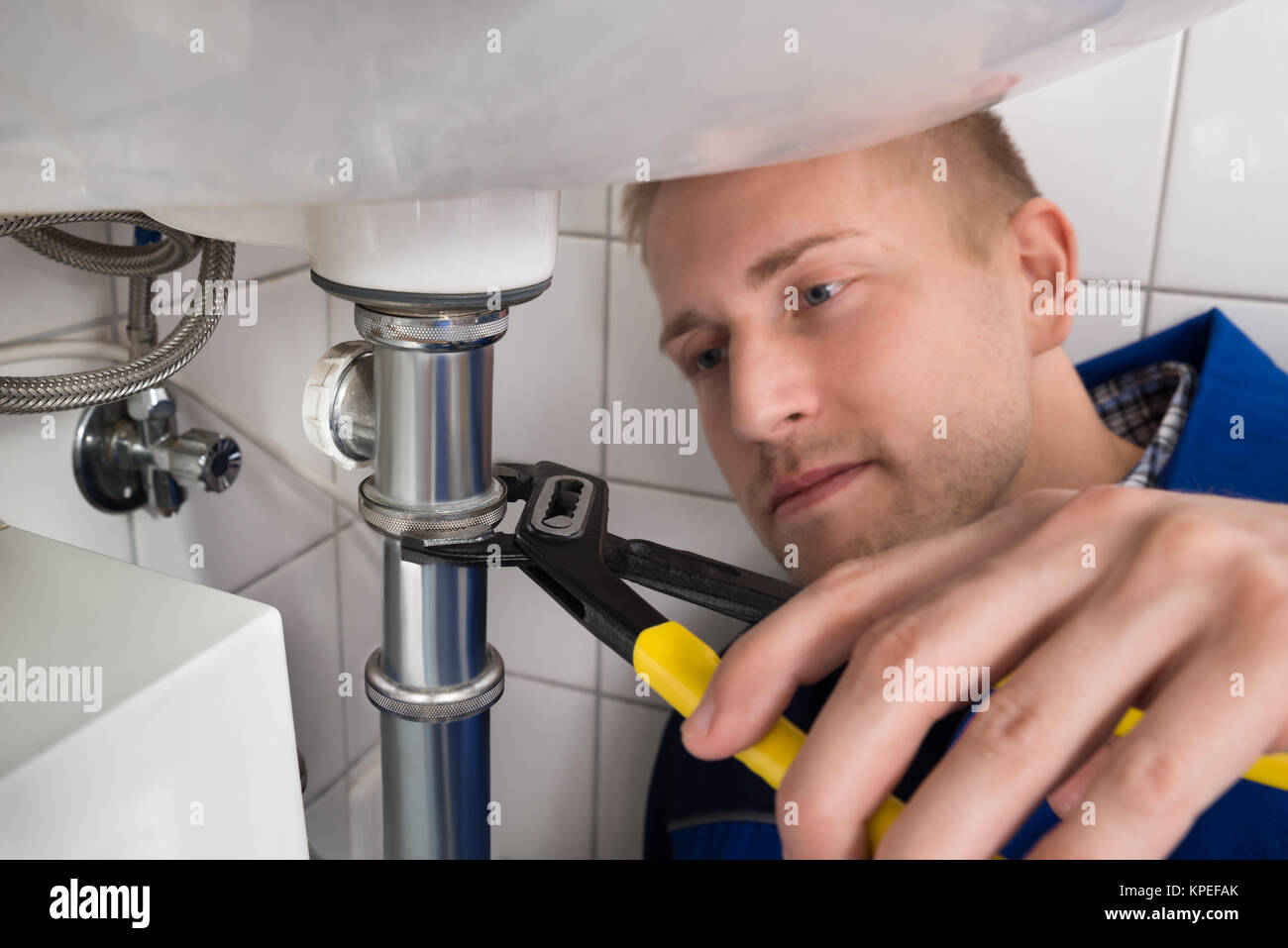Young Male Plumber Fixing Sink In Kitchen Stock Photo - Alamy