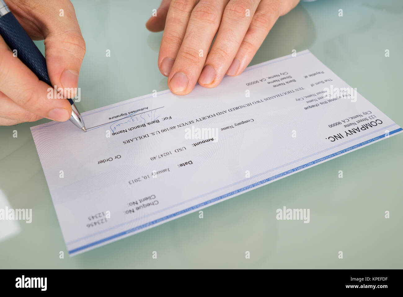 Person's Hand Signing Cheque Stock Photo - Alamy