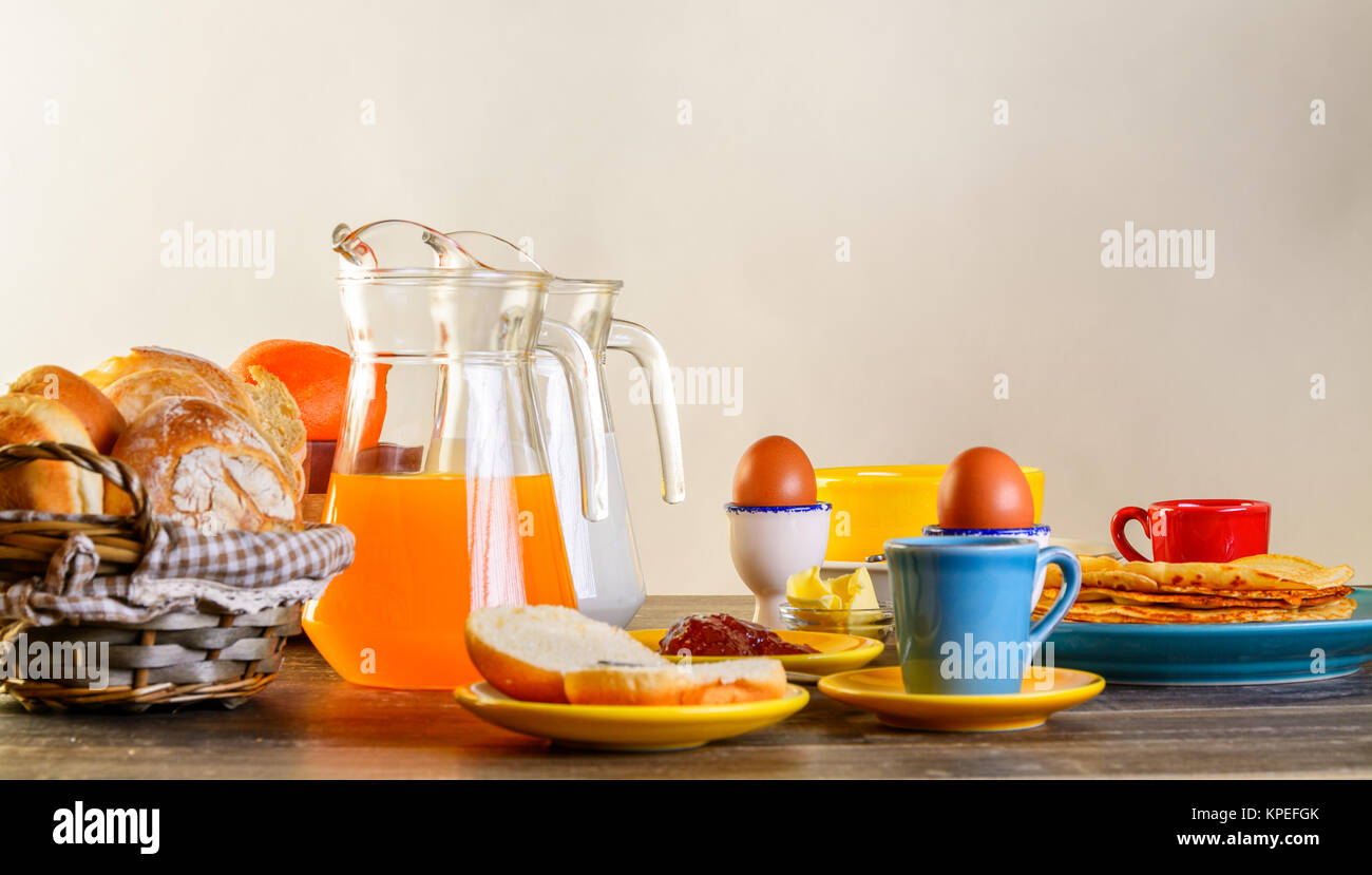 table of breakfast full set with eggs, pancakes, bread, jam ,juice and ...