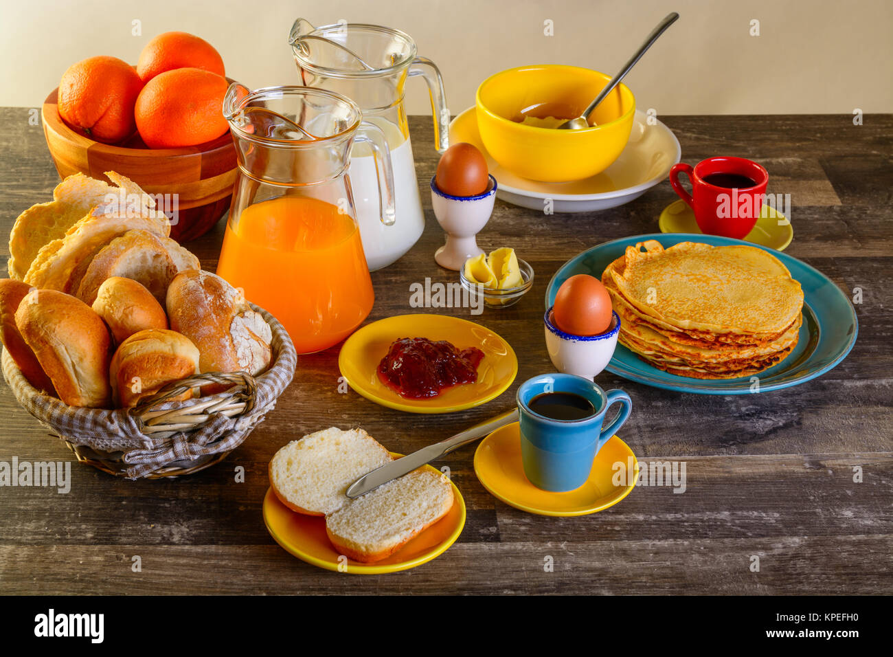 table of breakfast full set with eggs, pancakes, bread, jam ,juice and ...