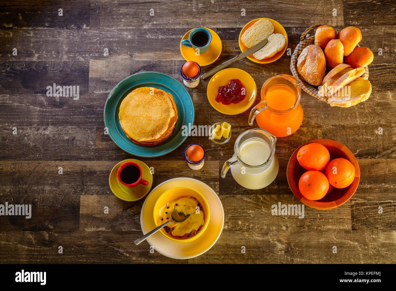 table of breakfast full set with eggs, pancakes, bread, jam ,juice and ...