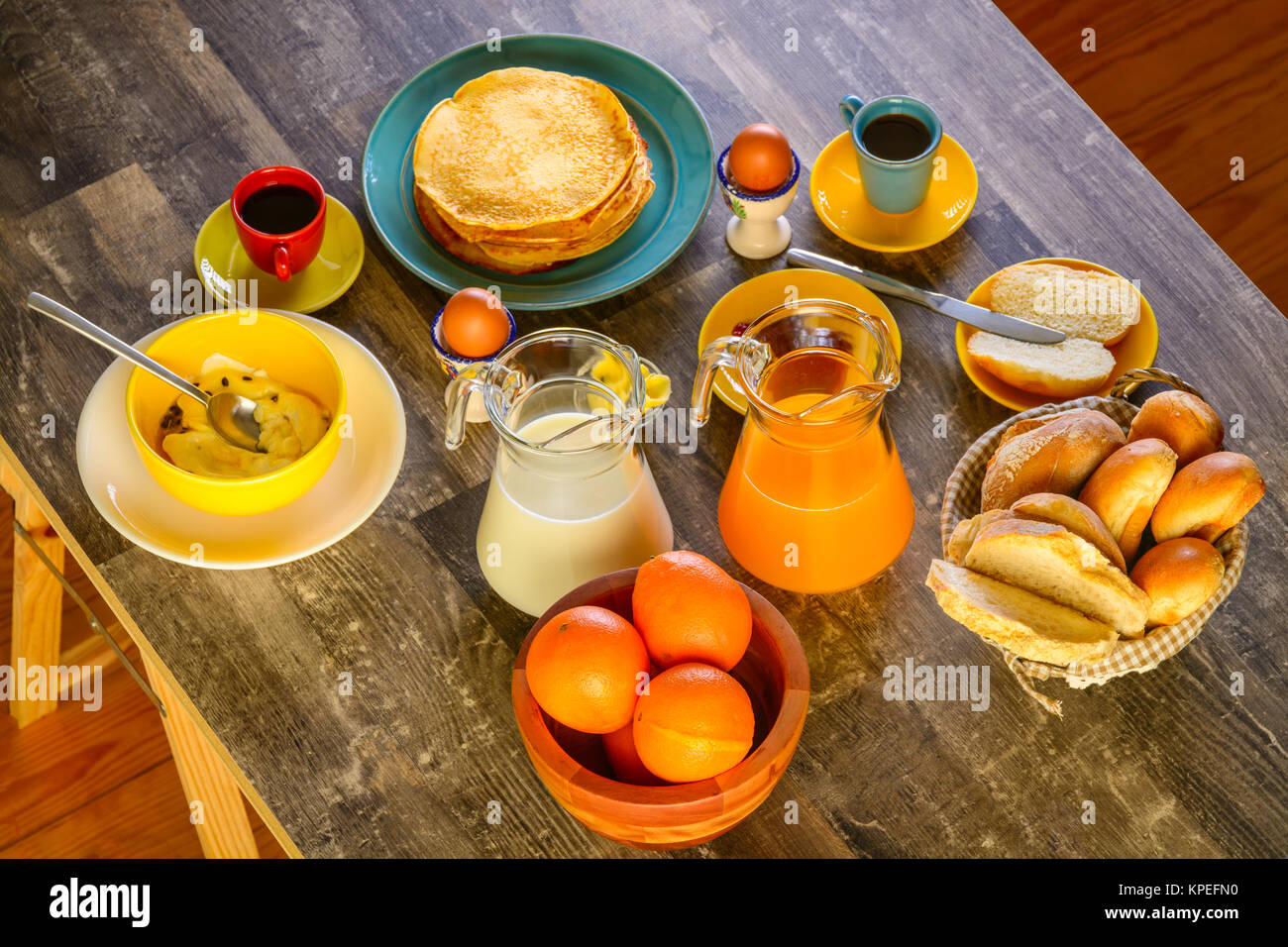 table of breakfast full set with eggs, pancakes, bread, jam ,juice and ...