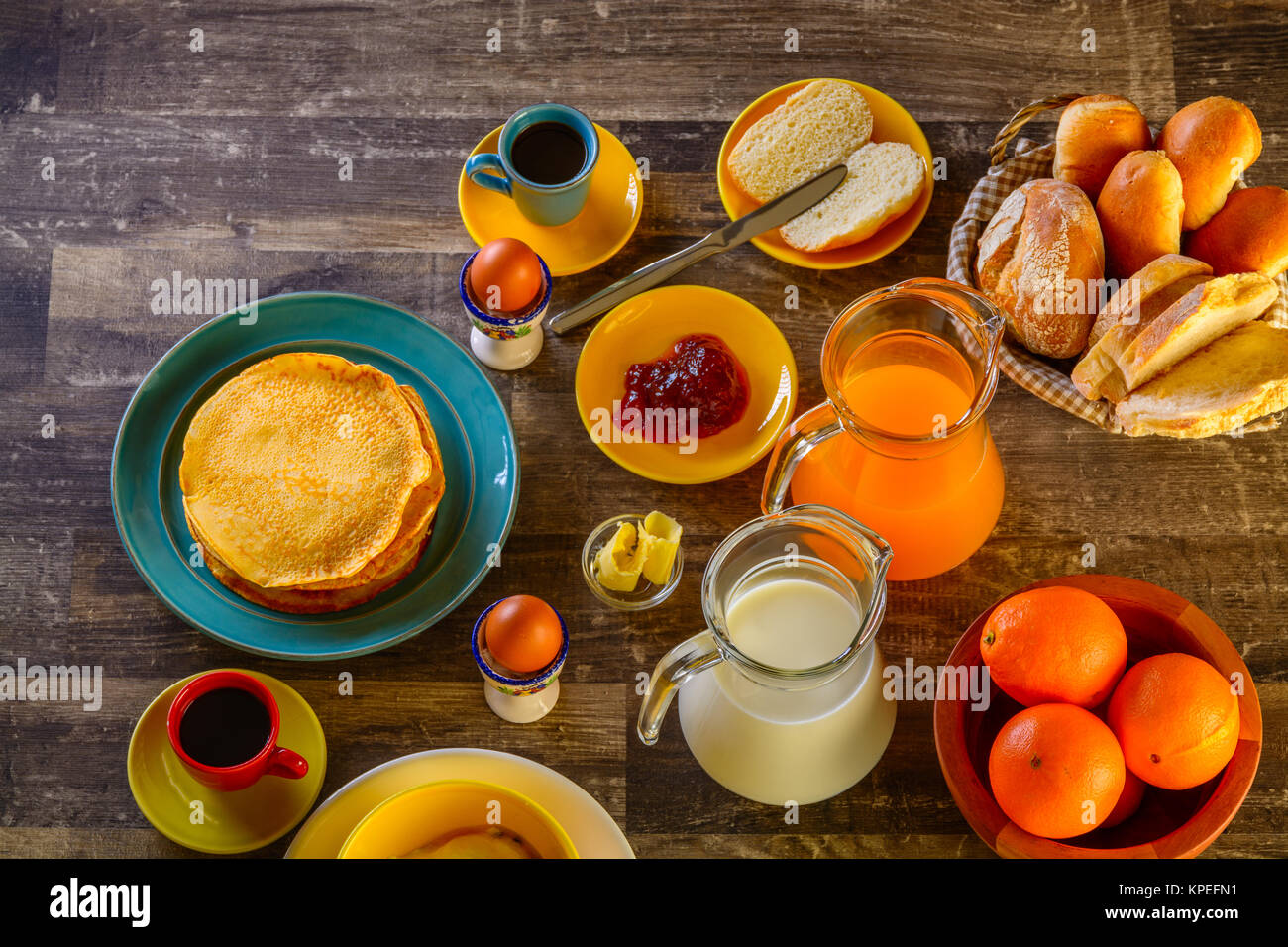 table of breakfast full set with eggs, pancakes, bread, jam ,juice and ...