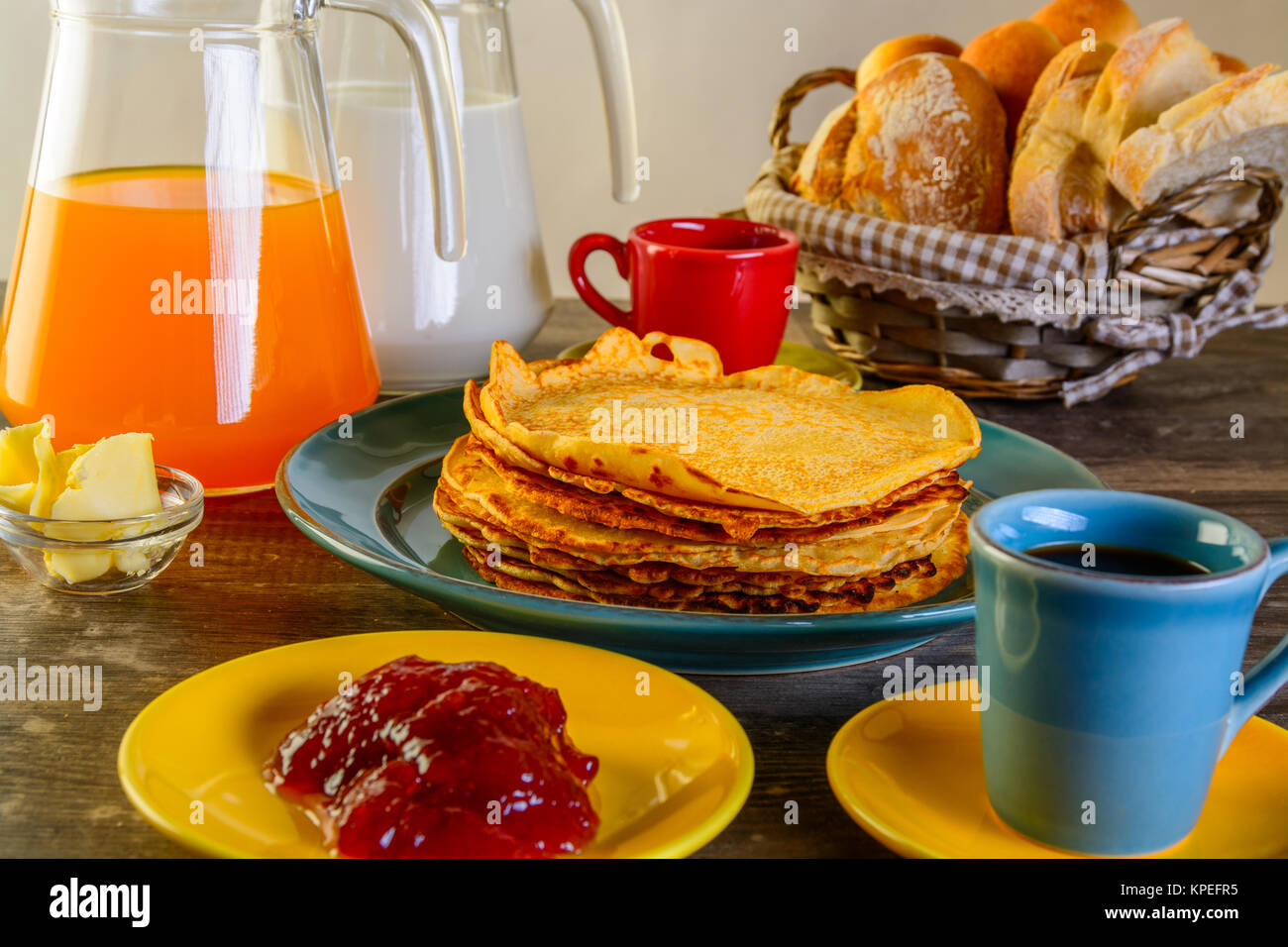 table of breakfast full set with eggs, pancakes, bread, jam ,juice and ...