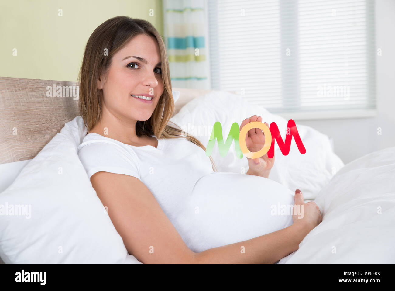 Pregnant Woman Holding Text Mom Stock Photo - Alamy