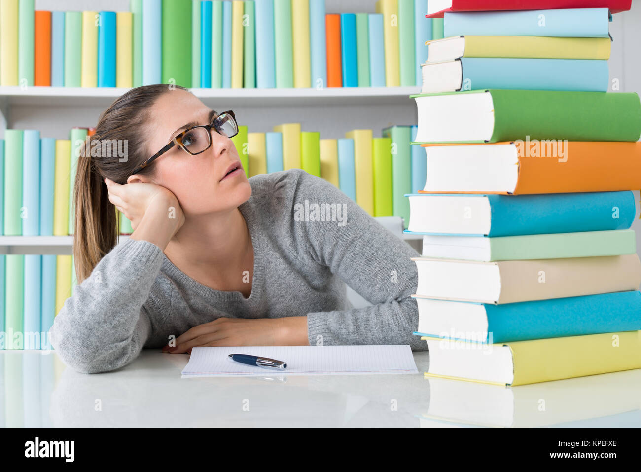 Contemplating Woman Sitting At Desk Stock Photo - Alamy