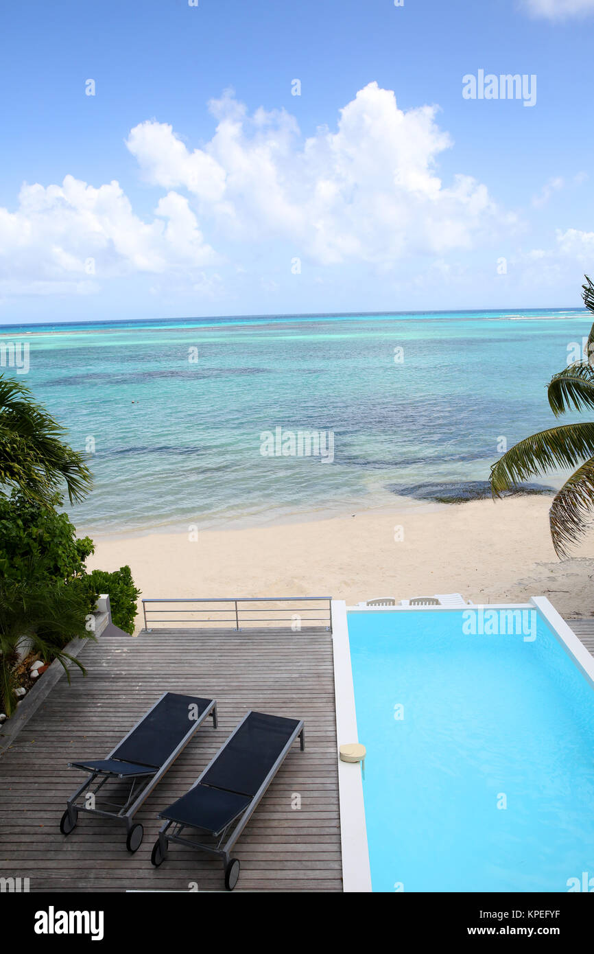 Upper view of pool and long chairs by the sea Stock Photo - Alamy