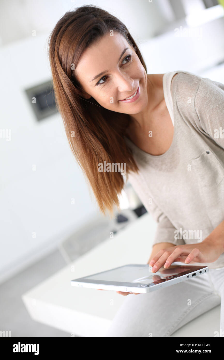 Young cheerful woman using electronic tablet Stock Photo - Alamy