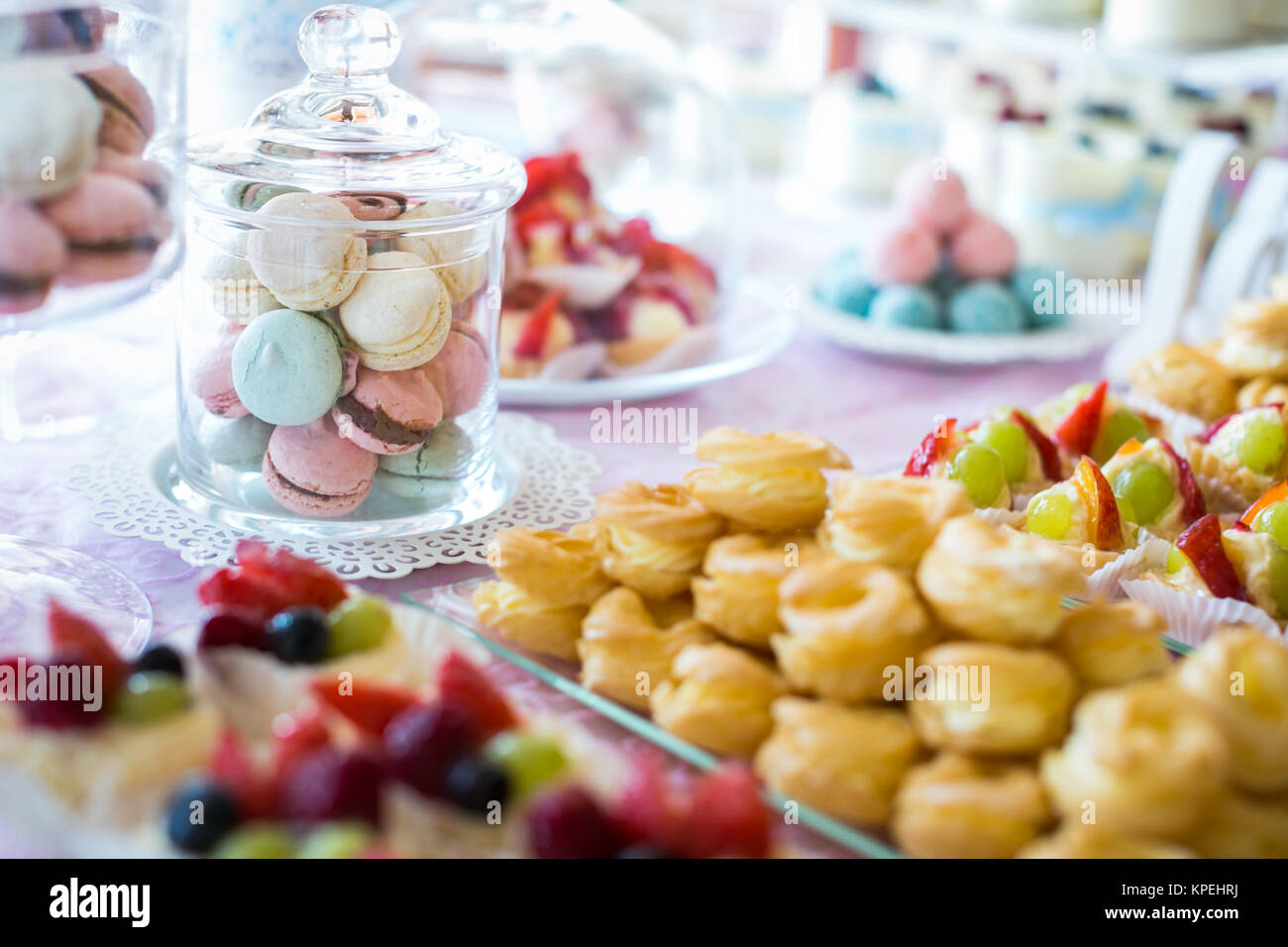 Table setting. Colorful macarons and cakes Stock Photo - Alamy