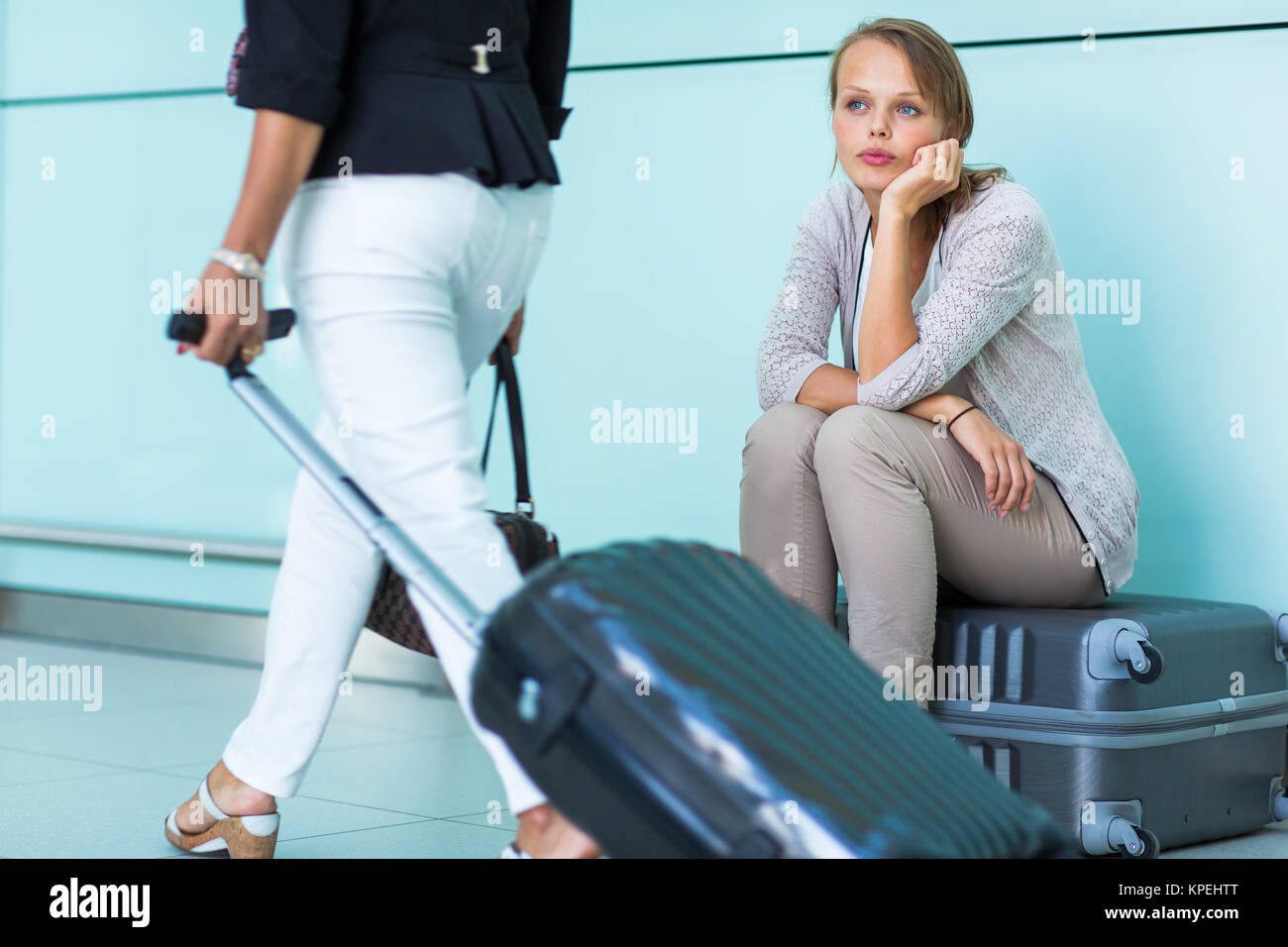 Young, female frustrated passenger at the airport, waiting desperately ...