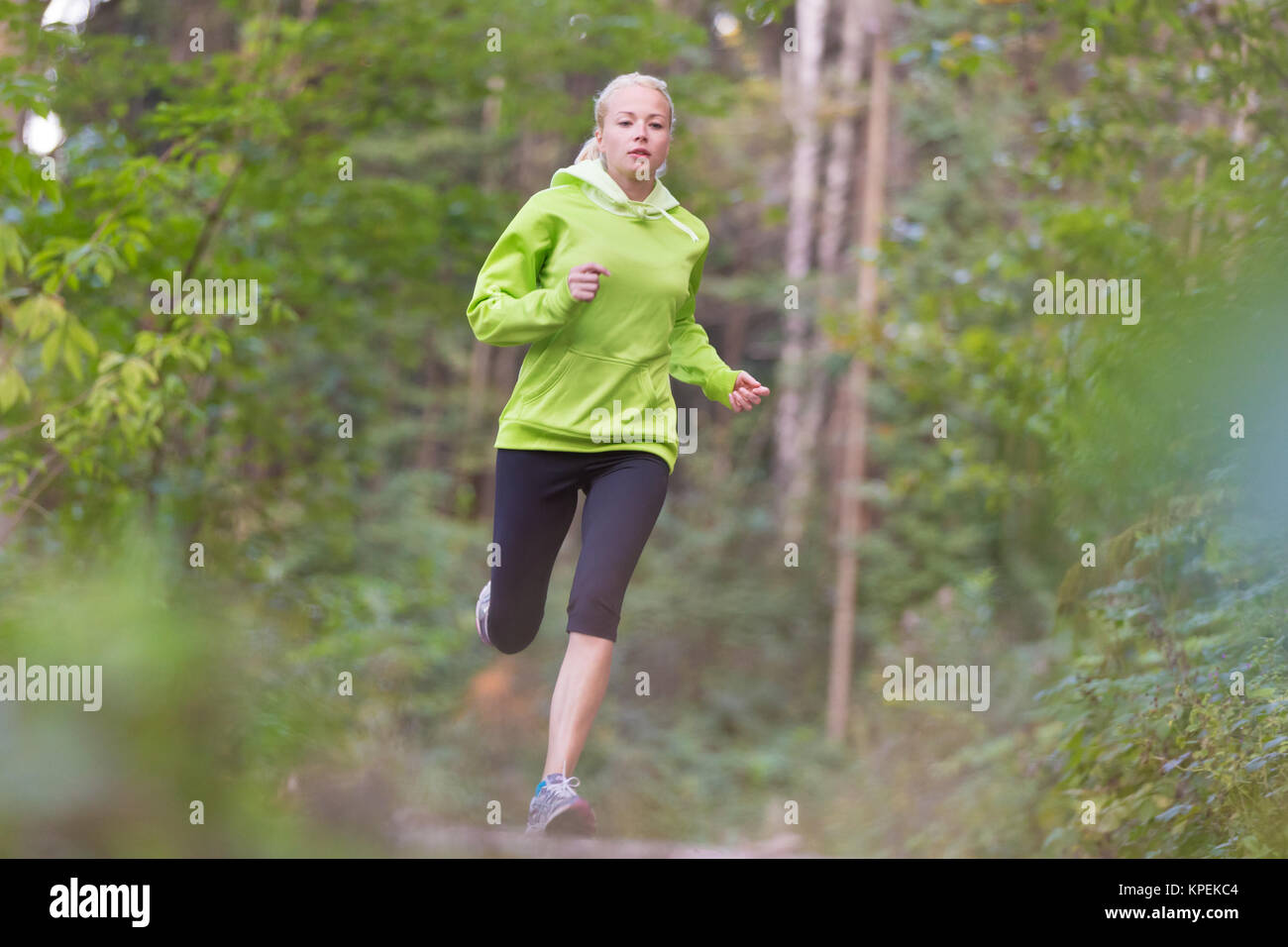 Pretty young girl runner in the forest Stock Photo - Alamy