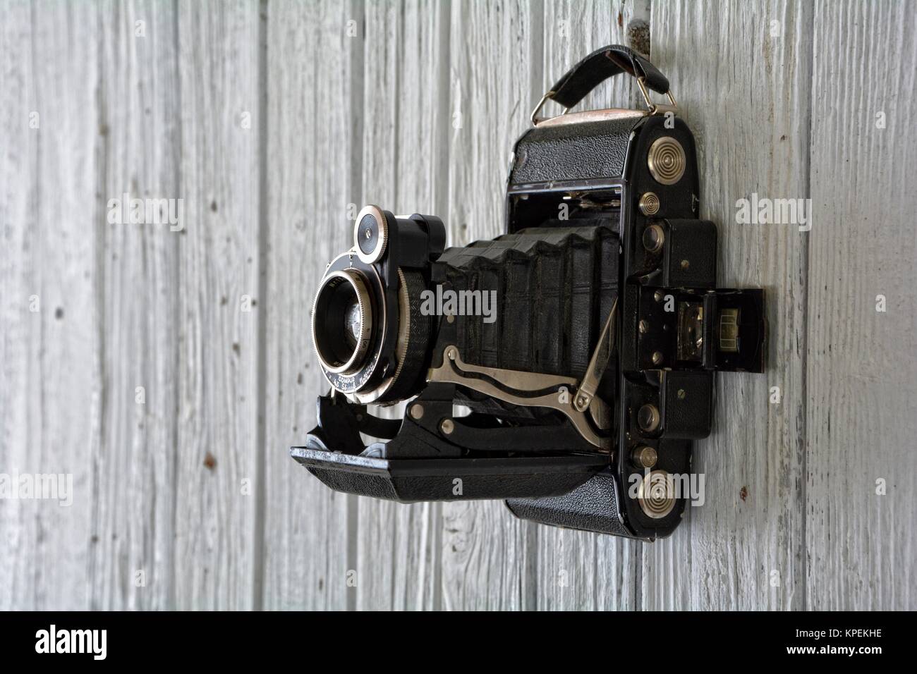 old camera hangs on old white wooden wall Stock Photo - Alamy