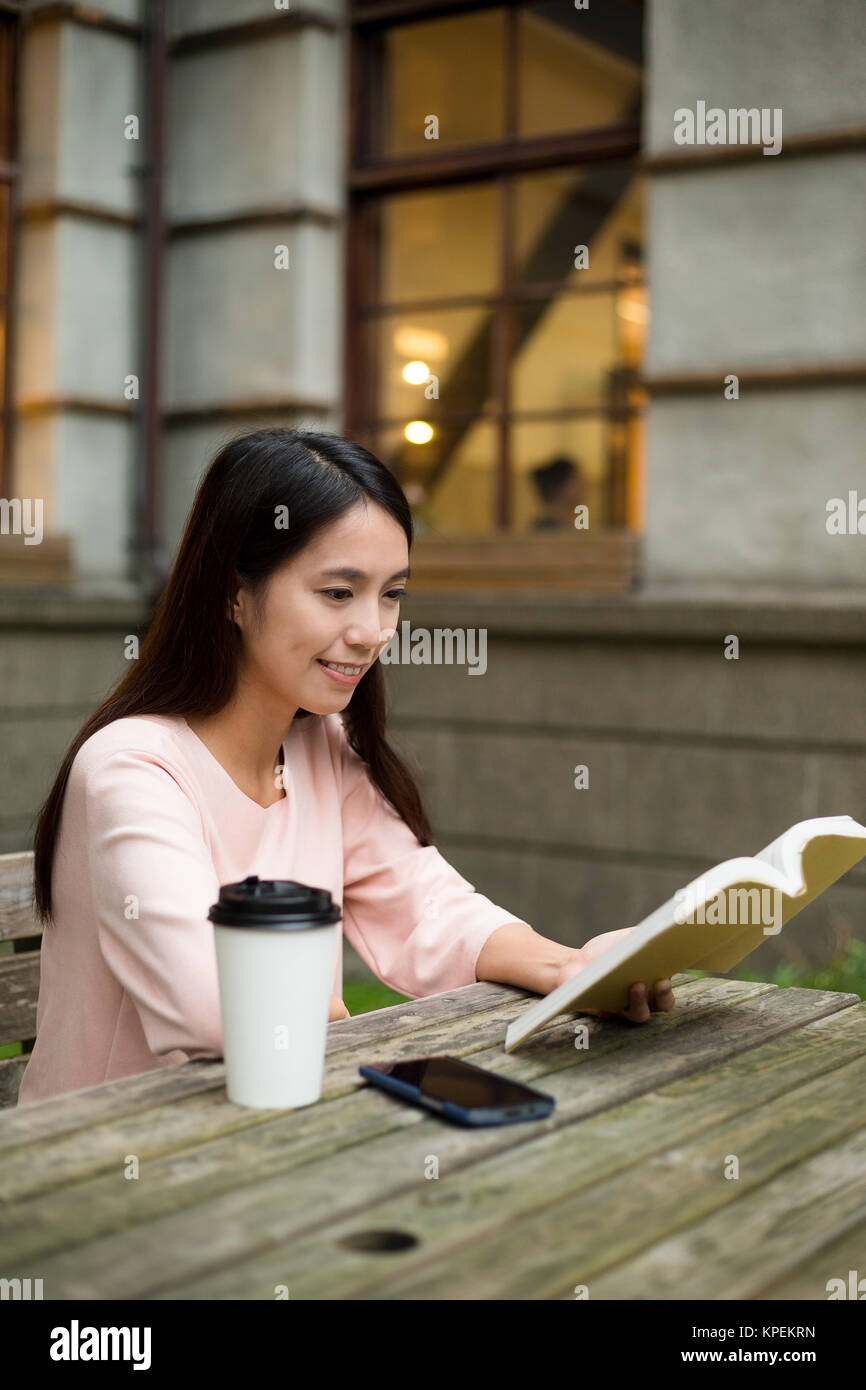 Asian Woman reading book at outdoor cafe Stock Photo - Alamy