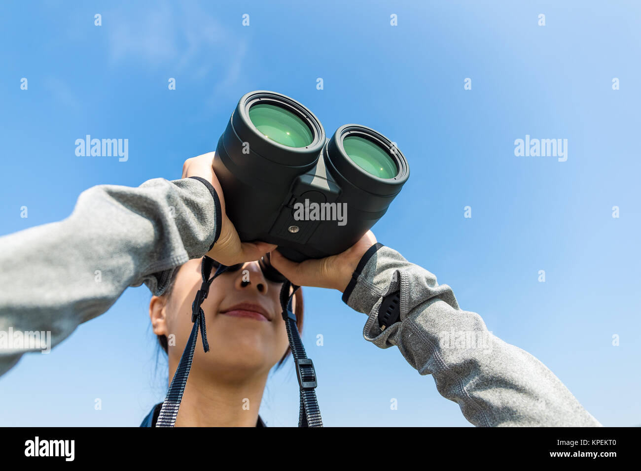Woman use of the binoculars with clear blue sky Stock Photo - Alamy