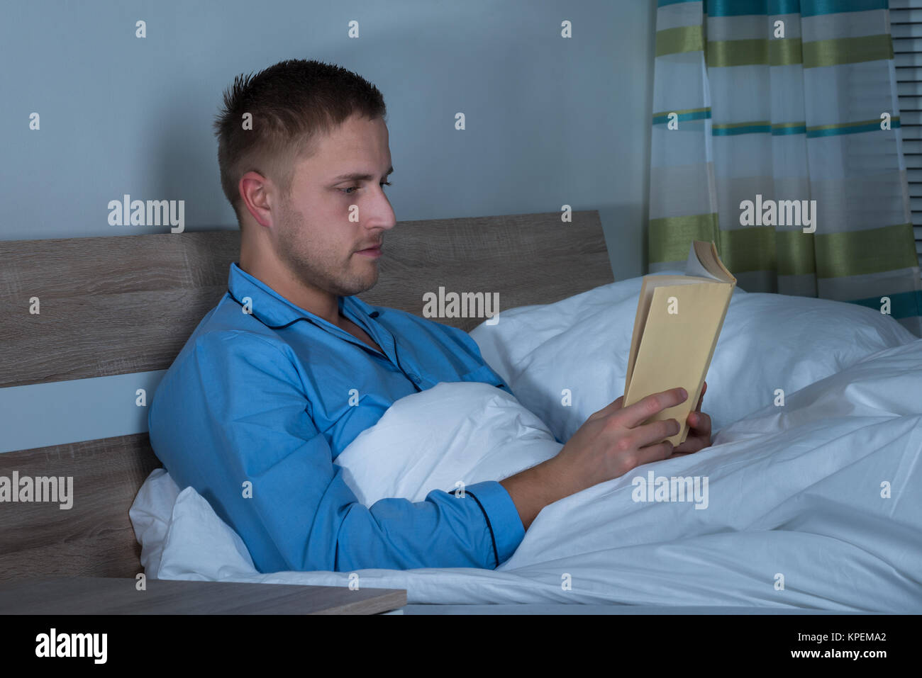 Man Reading Book In His Bedroom Stock Photo - Alamy