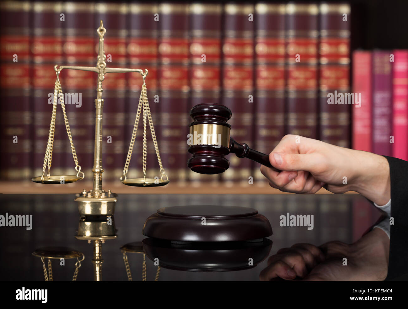 Judge Striking The Gavel At Desk Against Bookshelf Stock Photo - Alamy