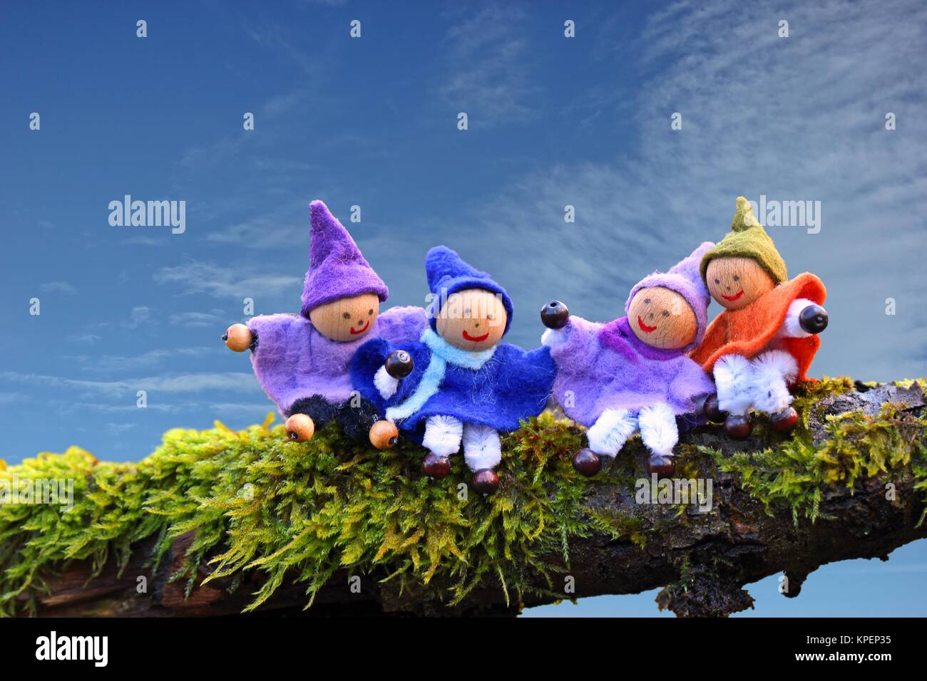 Four small gnomes sit on mossy branch Stock Photo - Alamy