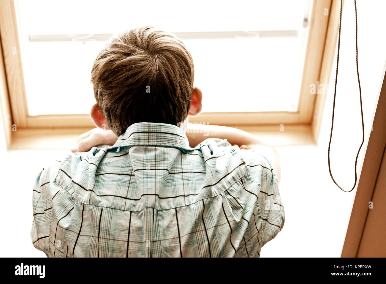 Rear view of teen looking out of window Stock Photo - Alamy