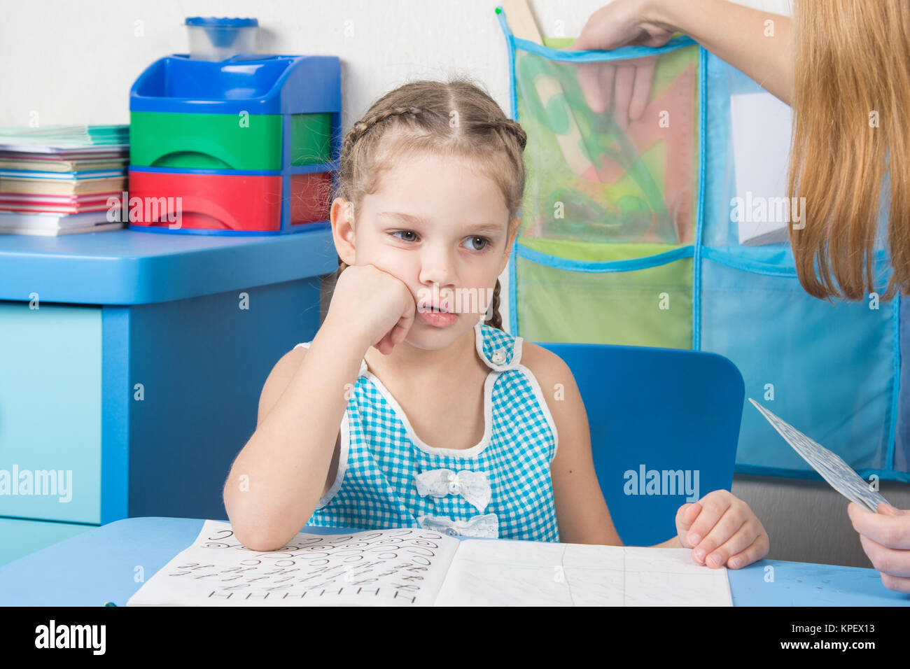 Five-year girl thought doing spelling under the supervision of a tutor ...