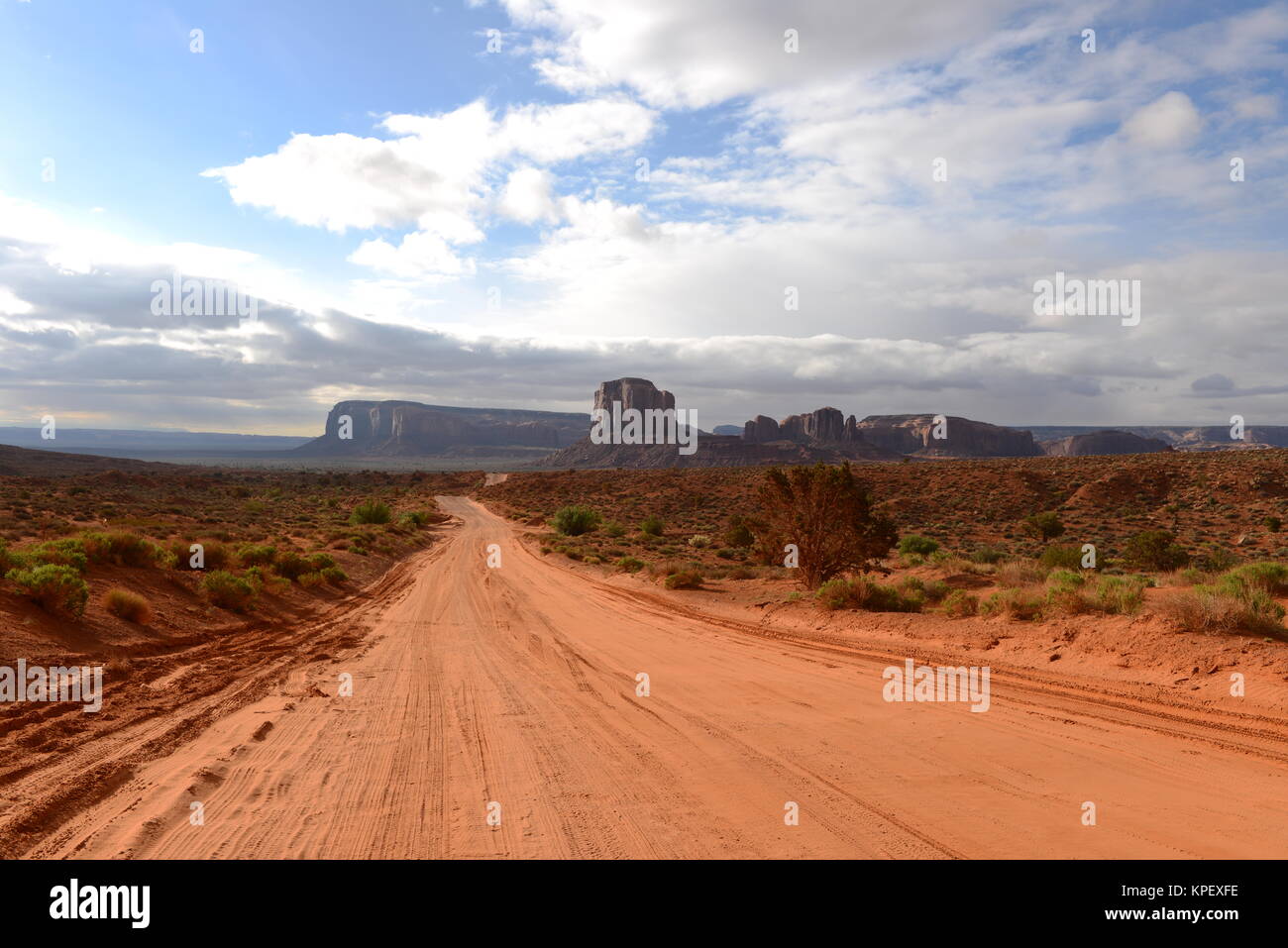 Desert Valley Road - A unpaved red sandy road extending into a desert ...
