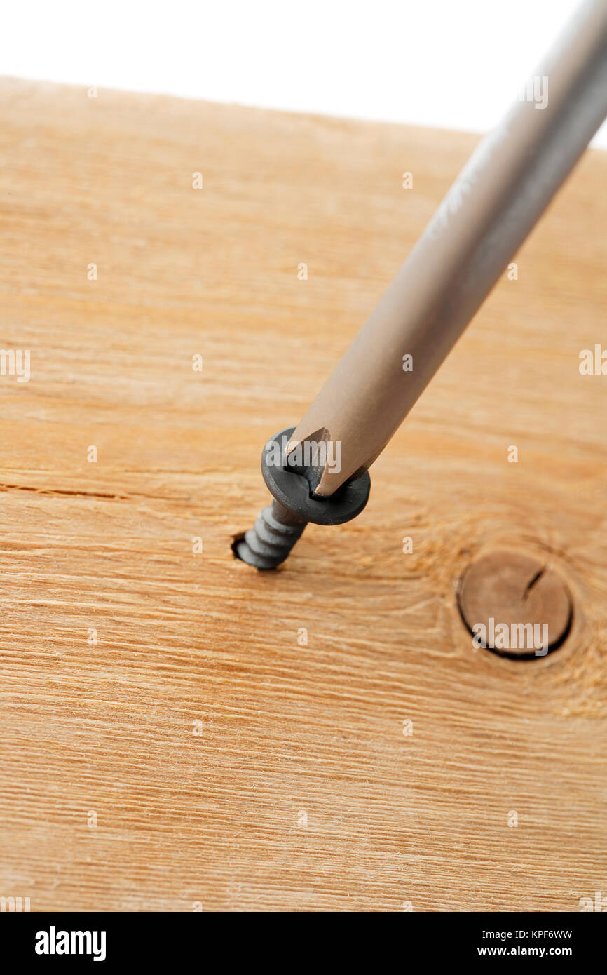 screw driven by screw driver to a wood Stock Photo - Alamy