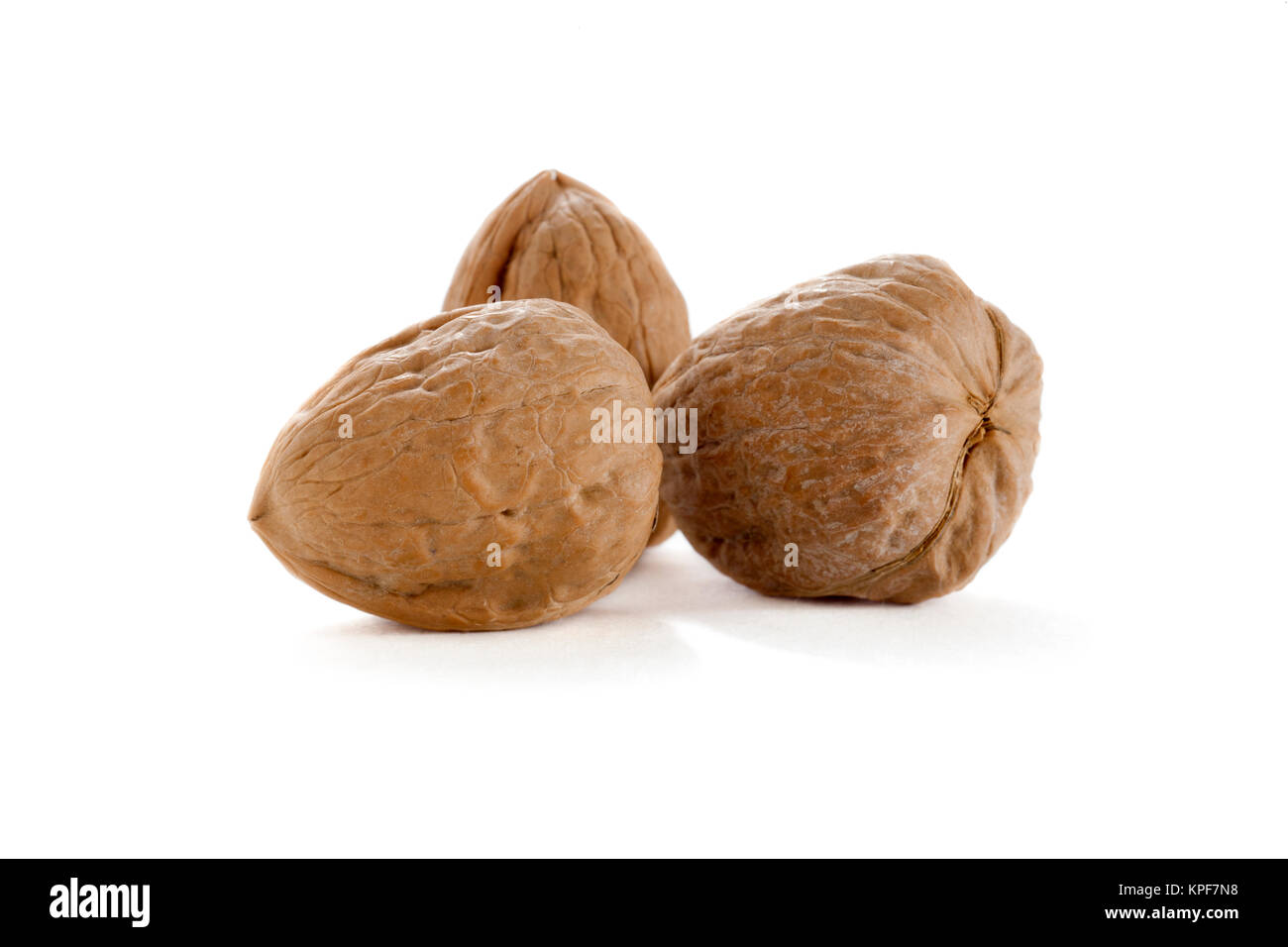 three whole walnuts Stock Photo - Alamy