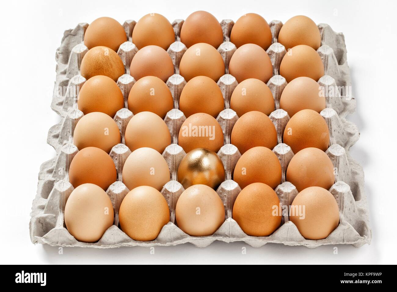 golden egg in a row of the brown eggs Stock Photo - Alamy