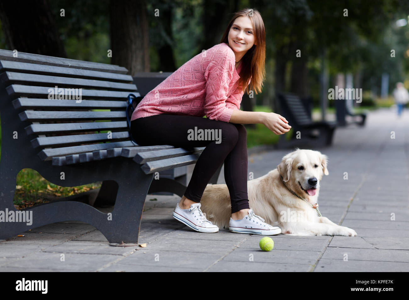 Photo of smiling girl sitting on bench, dog retriever Stock Photo - Alamy