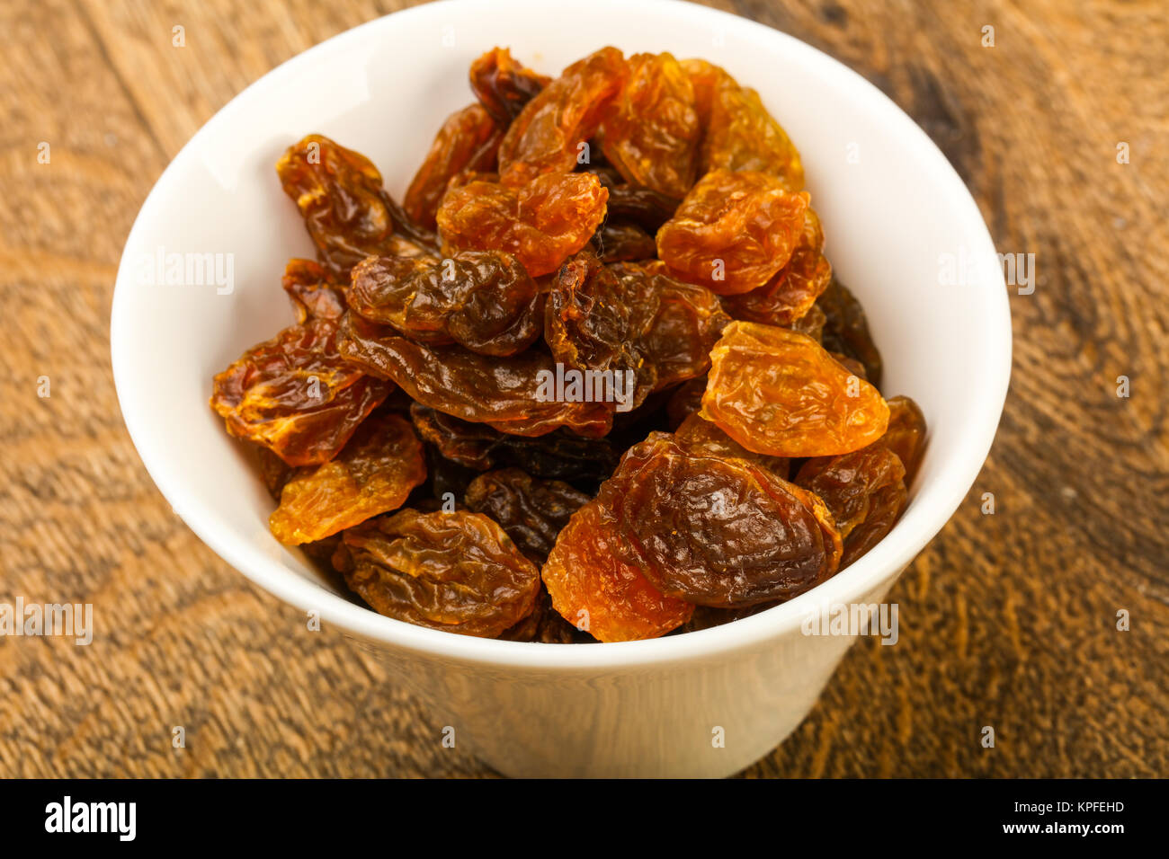 Dry Raisin in the bowl over the wooden background Stock Photo - Alamy