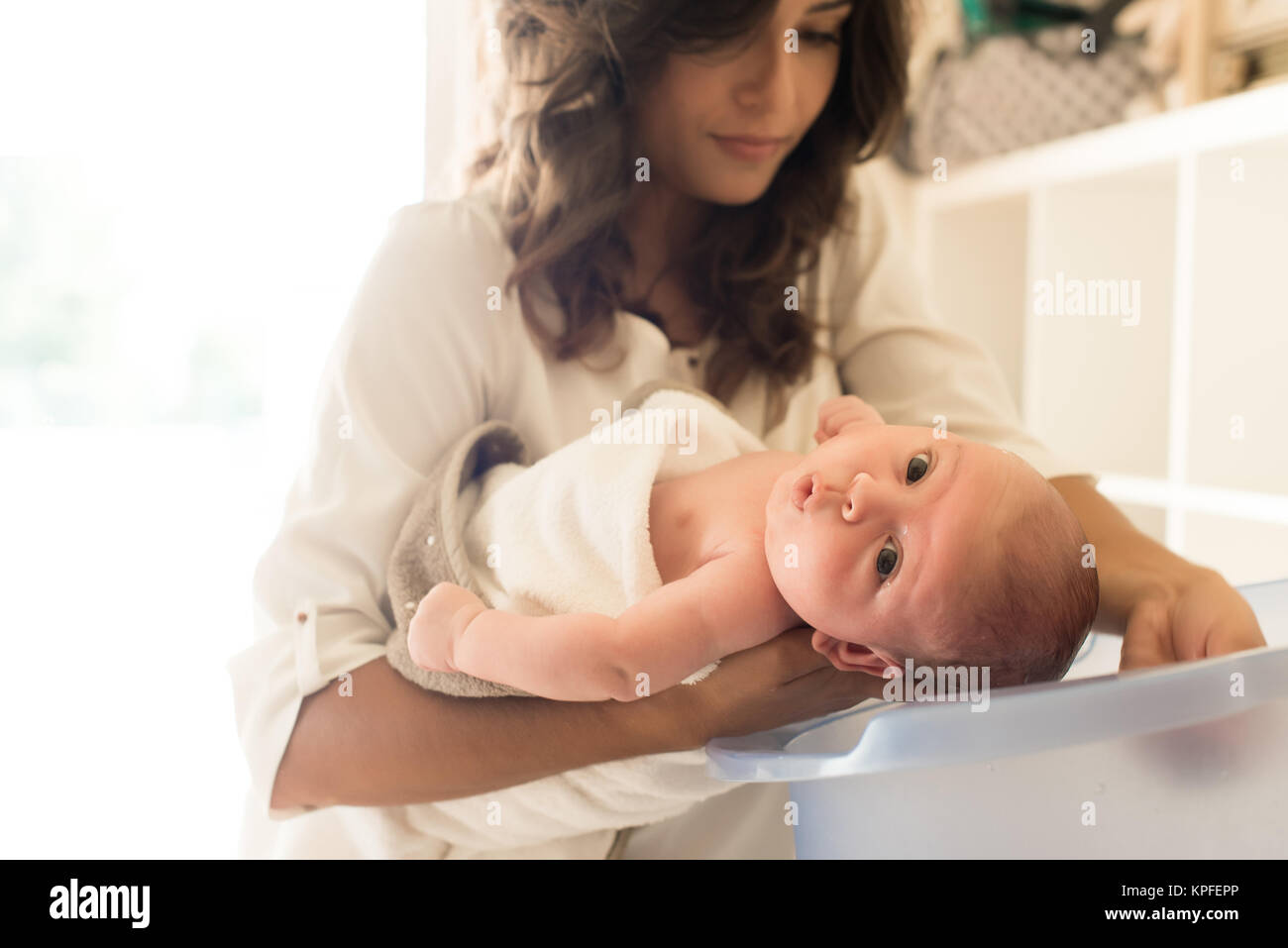 Mother washing a newborn baby in a bath tub Stock Photo - Alamy