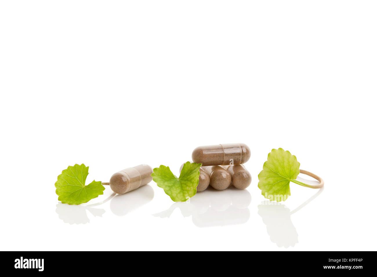 Gotu kola gel-capsules with leaves isolated on white background ...