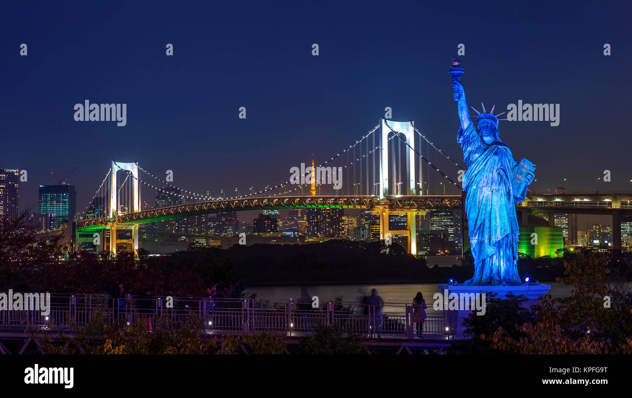 TOKYO - NOV 22: Statue and rainbow bridge at night on November 22, 2017 ...
