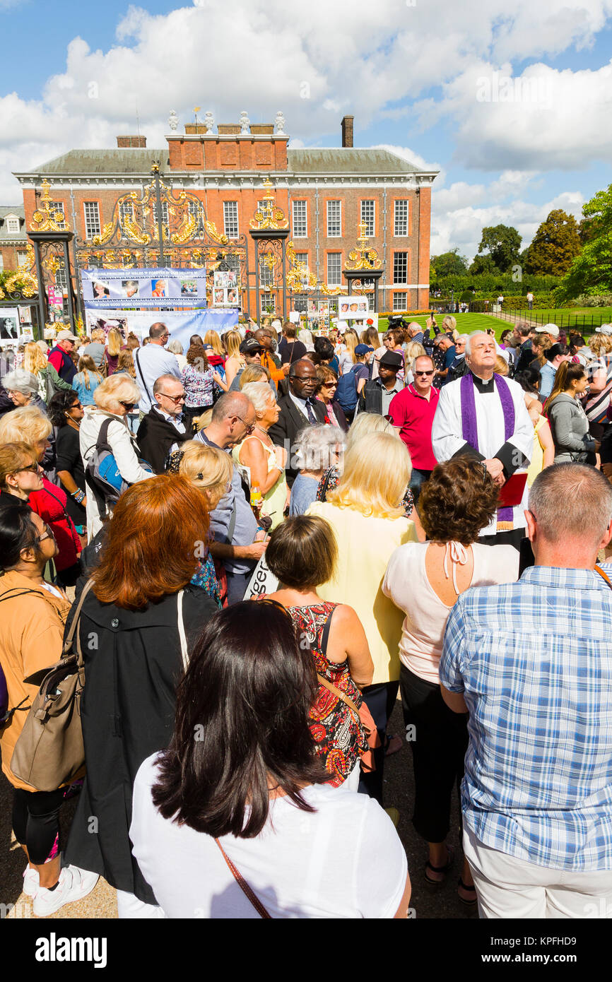 London, UK. A crowd gathers around retired pastor Father Frank Gelli as ...