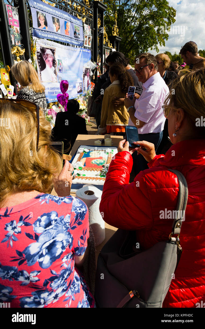 London, UK. Onlookers take photographs of a cake with a picture of ...