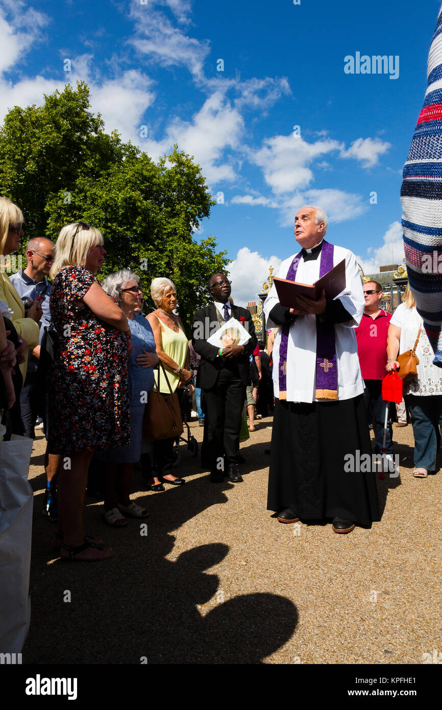 London, UK. A crowd gathers around retired pastor Father Frank Gelli as ...