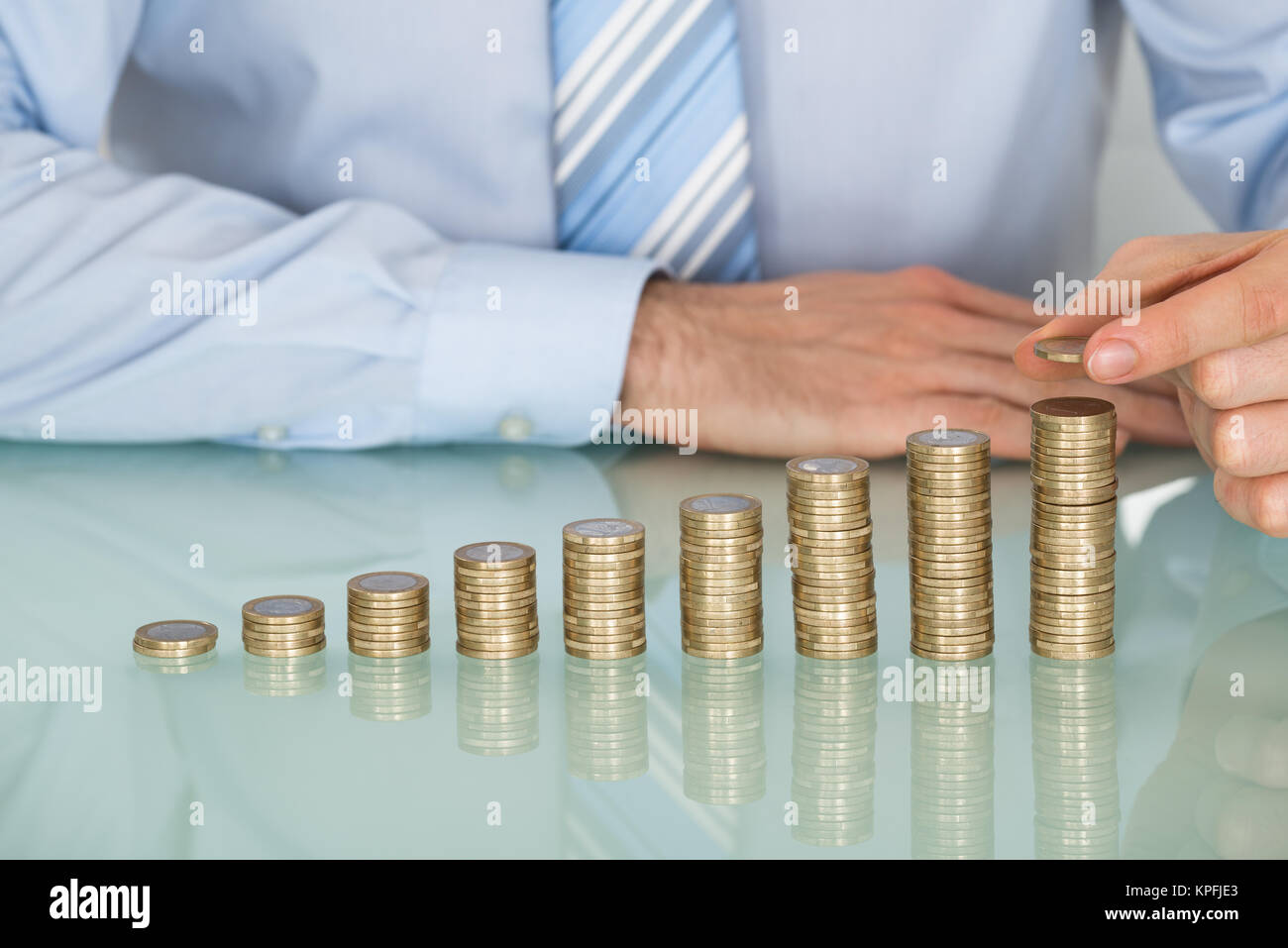 Businessman Making Stack Of Coins Stock Photo - Alamy
