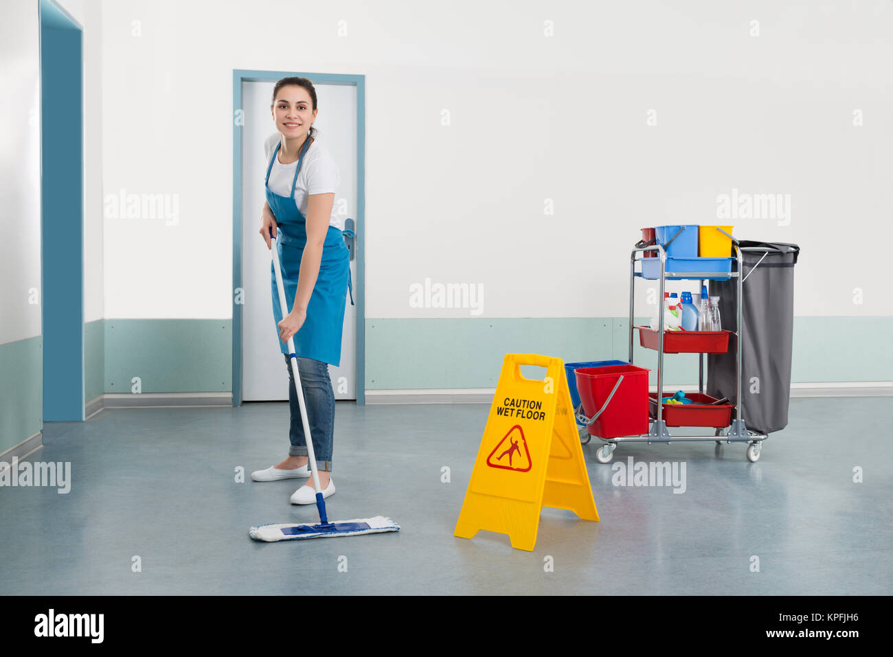 Female Janitor Mopping Corridor Stock Photo - Alamy