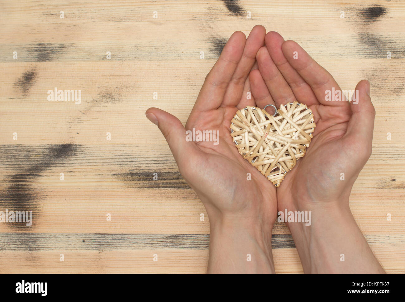 straw heart in hand on wooden background Stock Photo - Alamy