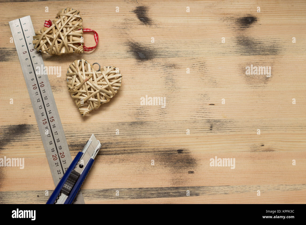 Two straw heart, ruler and knife on wooden background Stock Photo - Alamy