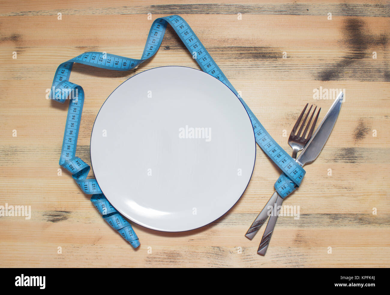Empty plate with blue measure tape, knife and fork Stock Photo - Alamy