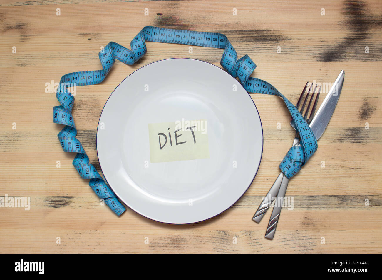 Empty plate with blue measure tape, knife and fork Stock Photo - Alamy