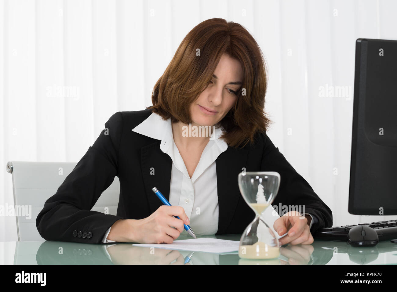Businesswoman Filling Form In Office Stock Photo - Alamy