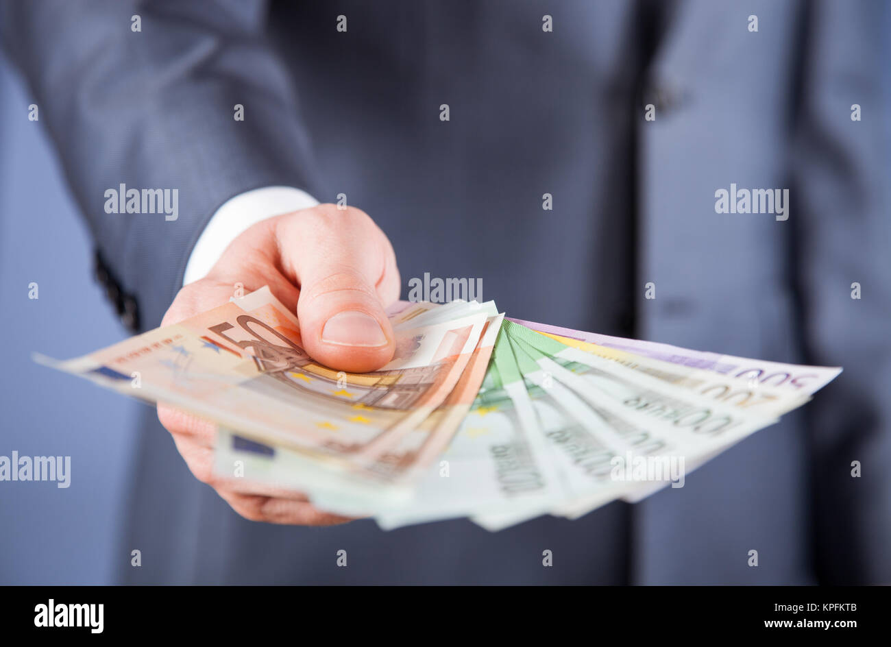 Businessman's hand reaching out euro banknotes Stock Photo - Alamy