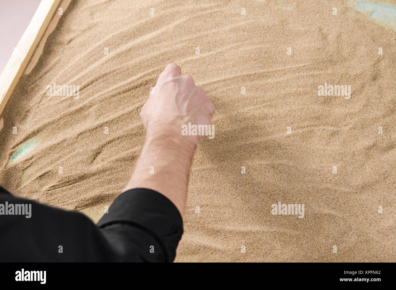 the man was about to draw something with his finger on the sand Stock ...