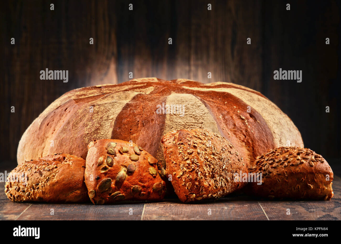 Composition with large loaf of bread and four rolls Stock Photo - Alamy