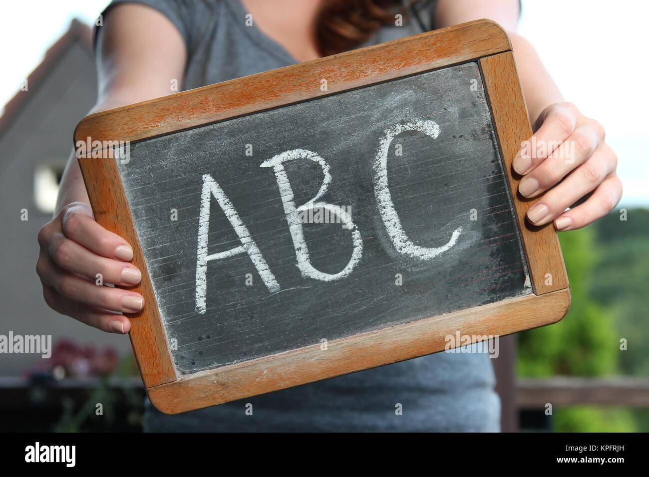 ABC written with chalk on slate shown by young female Stock Photo - Alamy