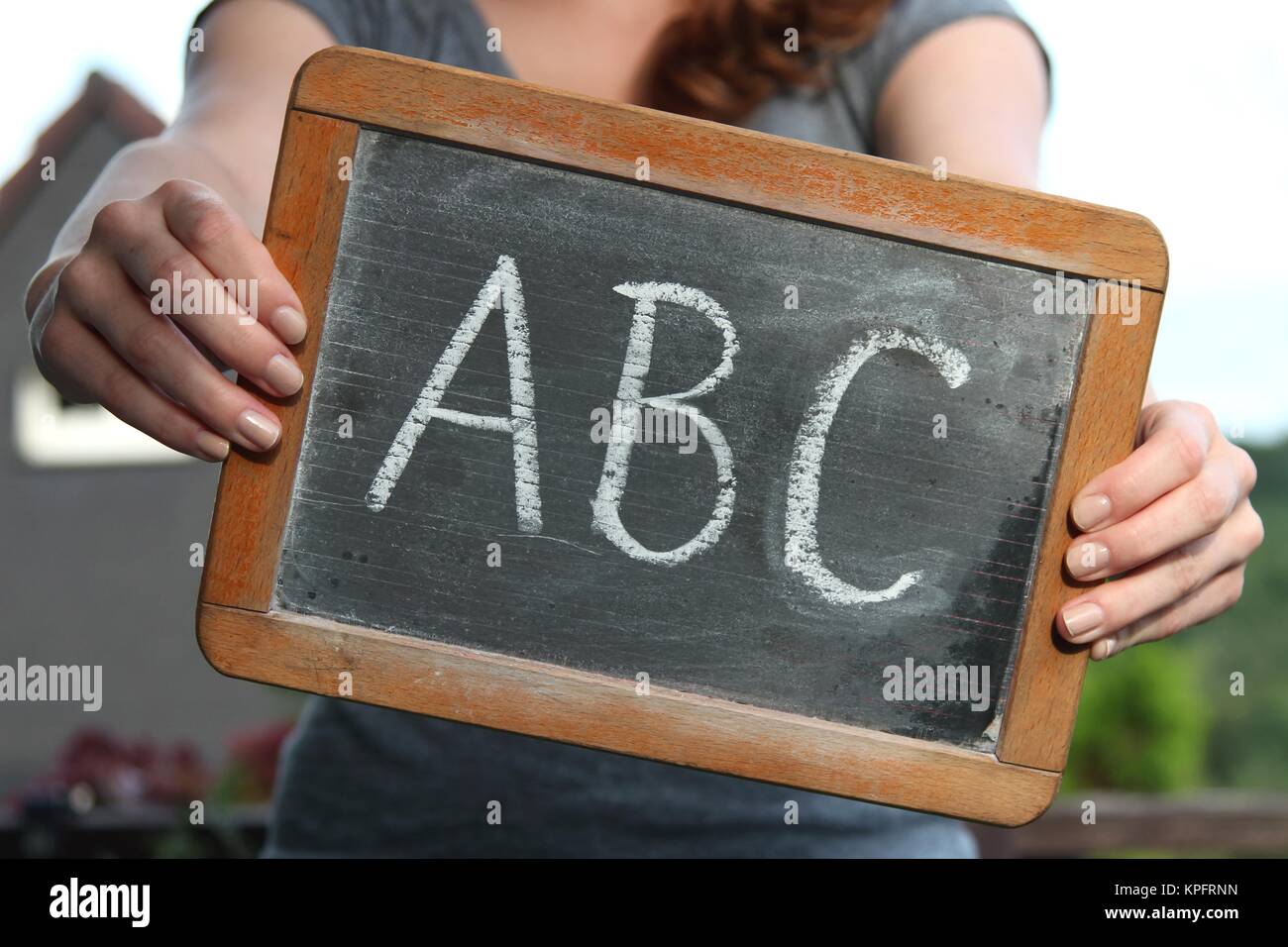 ABC written with chalk on slate shown by young female Stock Photo - Alamy