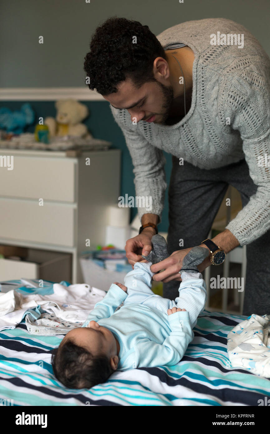 Young father dressing his son Stock Photo - Alamy