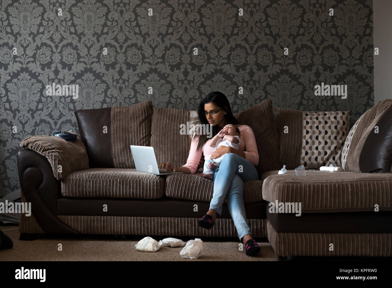 Mother multi-tasking work and son Stock Photo - Alamy